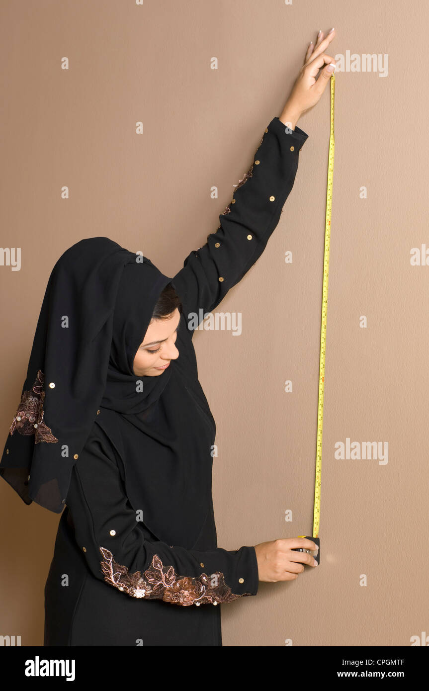Young woman holding measuring tape, smiling Stock Photo - Alamy