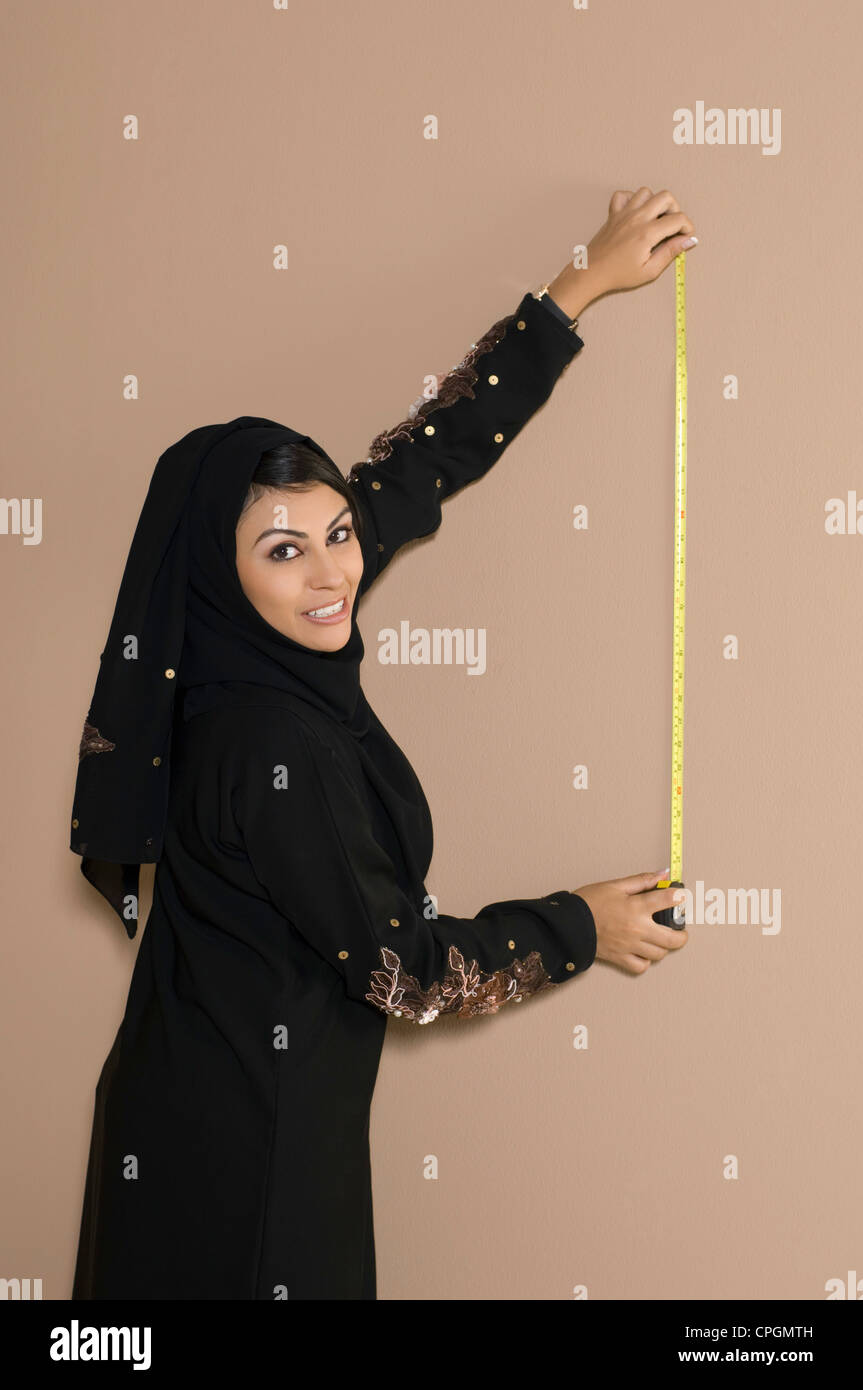 Young woman holding measuring tape, smiling, portrait Stock Photo - Alamy