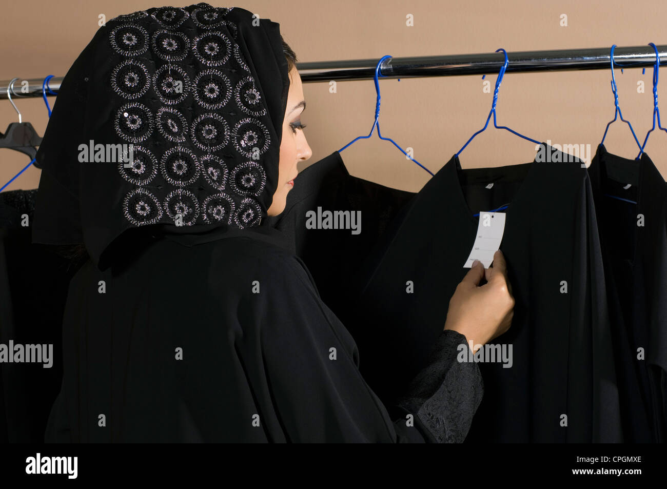 Young woman looking at price tag, side view Stock Photo - Alamy