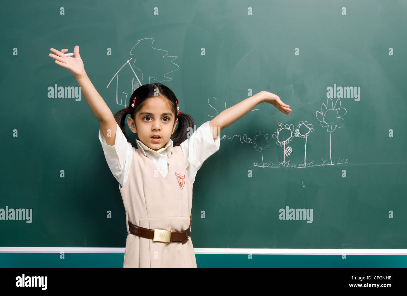 Girl (6-7) standing by board, arms raised Stock Photo - Alamy