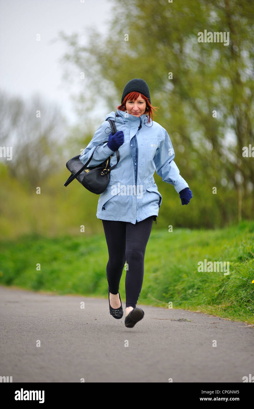 Woman running holding handbag Stock Photo - Alamy
