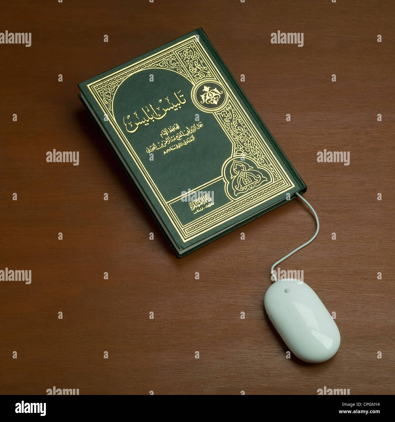 Computer mouse wire used as bookmark in book, close-up, elevated view ...