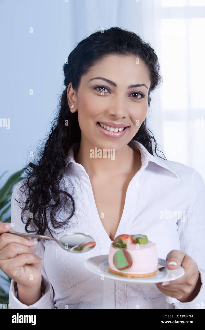Young woman eating custard, portrait Stock Photo - Alamy