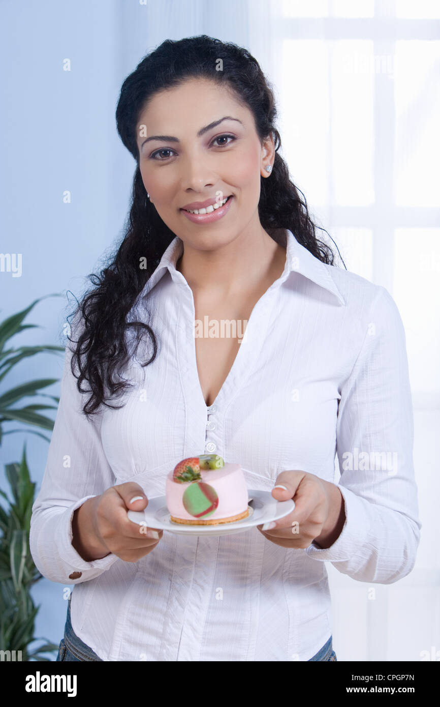Young woman holding custard in plate, portrait Stock Photo - Alamy