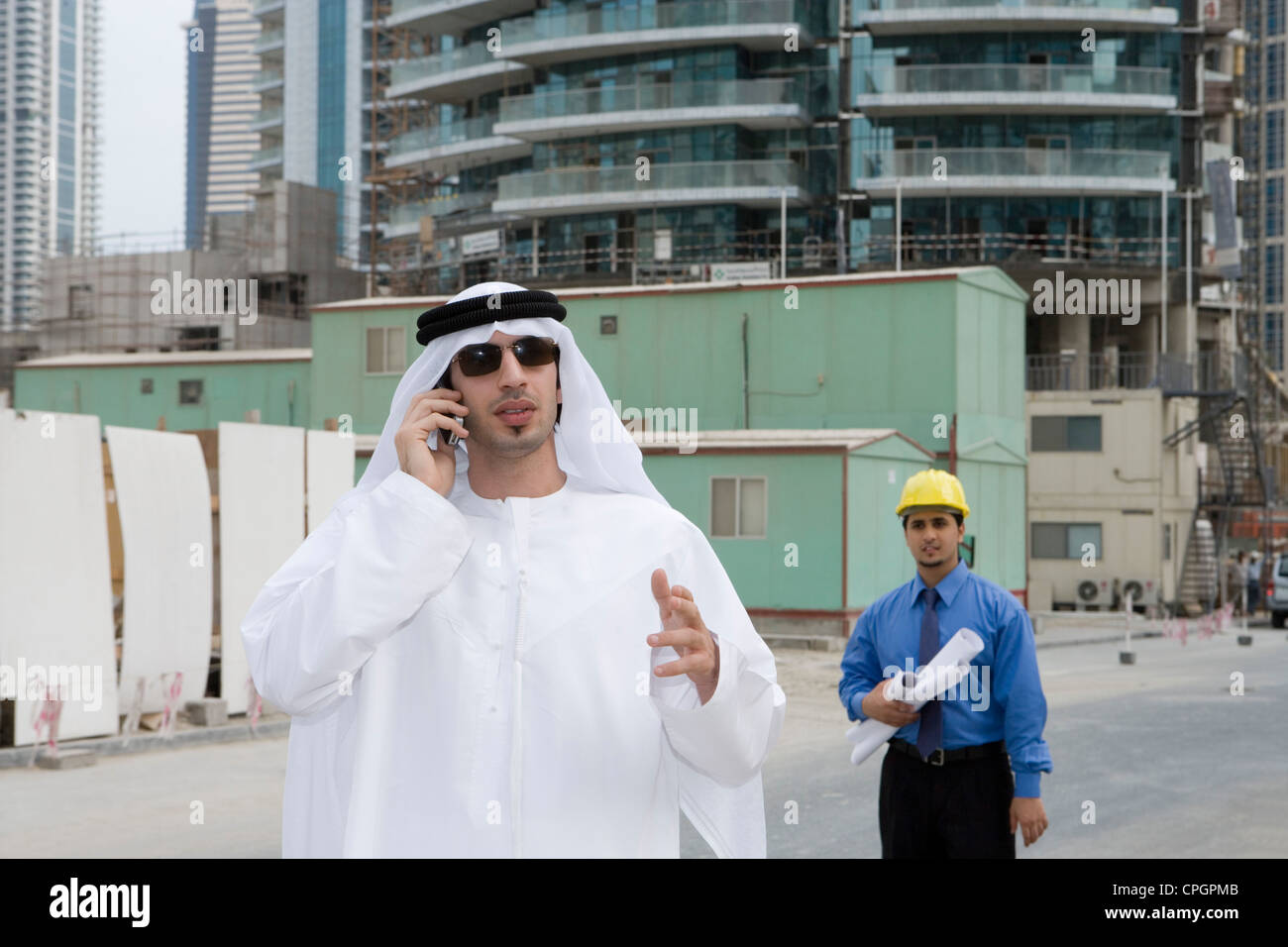Businessmen using mobile phone at construction site Stock Photo - Alamy
