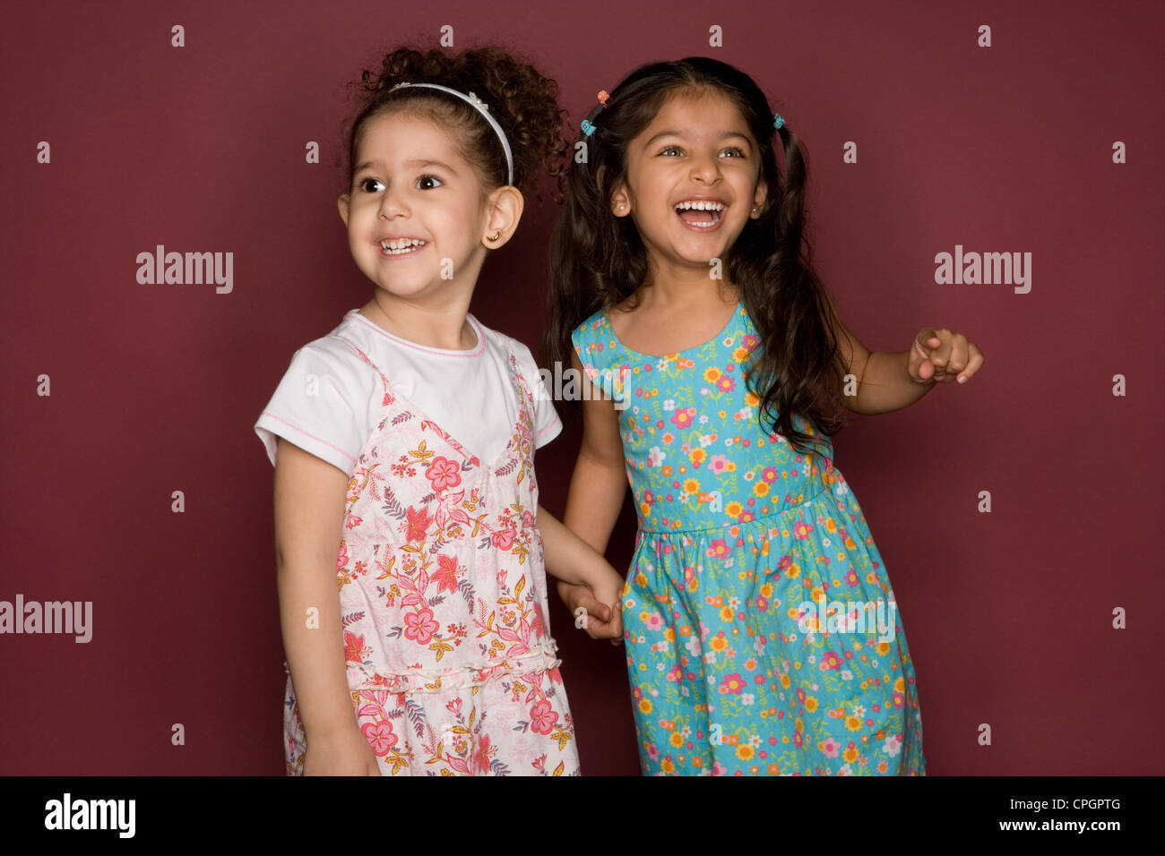 Girls holding hands, laughing Stock Photo - Alamy
