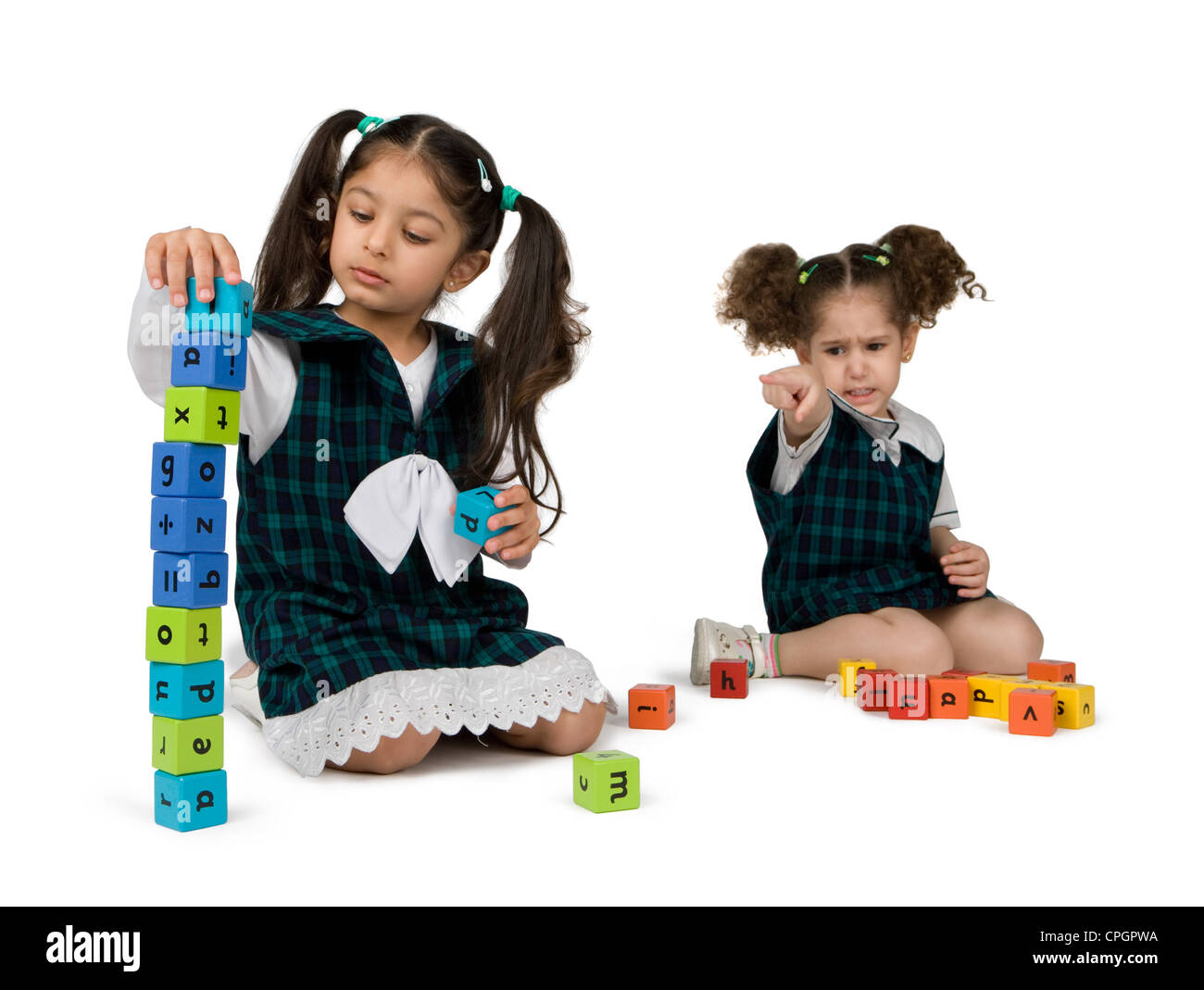 Girl playing with plastic blocks and friend in background Stock Photo ...