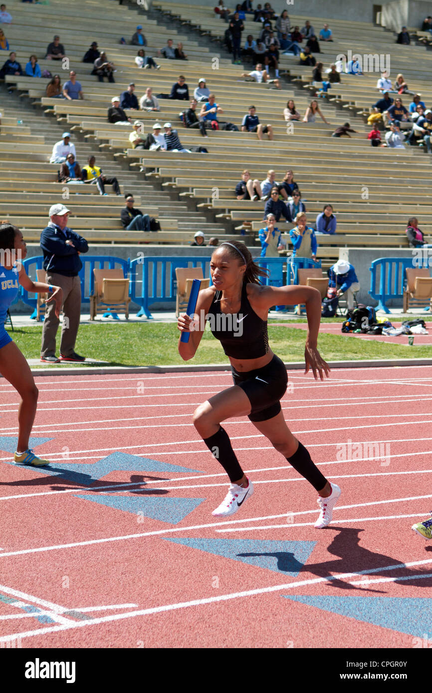 American Sprinter Allyson Felix with baton in hand running in a relay ...