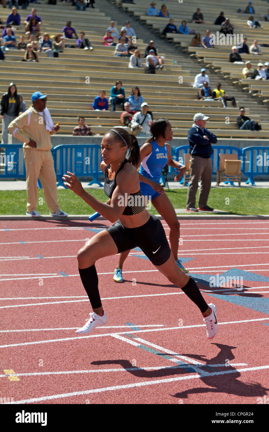 American Sprinter Allyson Felix with baton in hand running in a relay ...