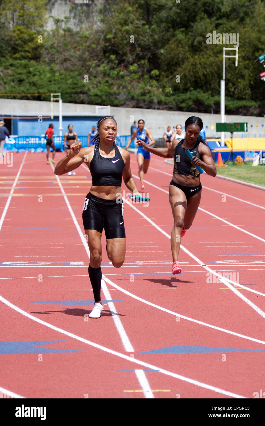 American Sprinter Allyson Felix with baton in hand running in a relay ...