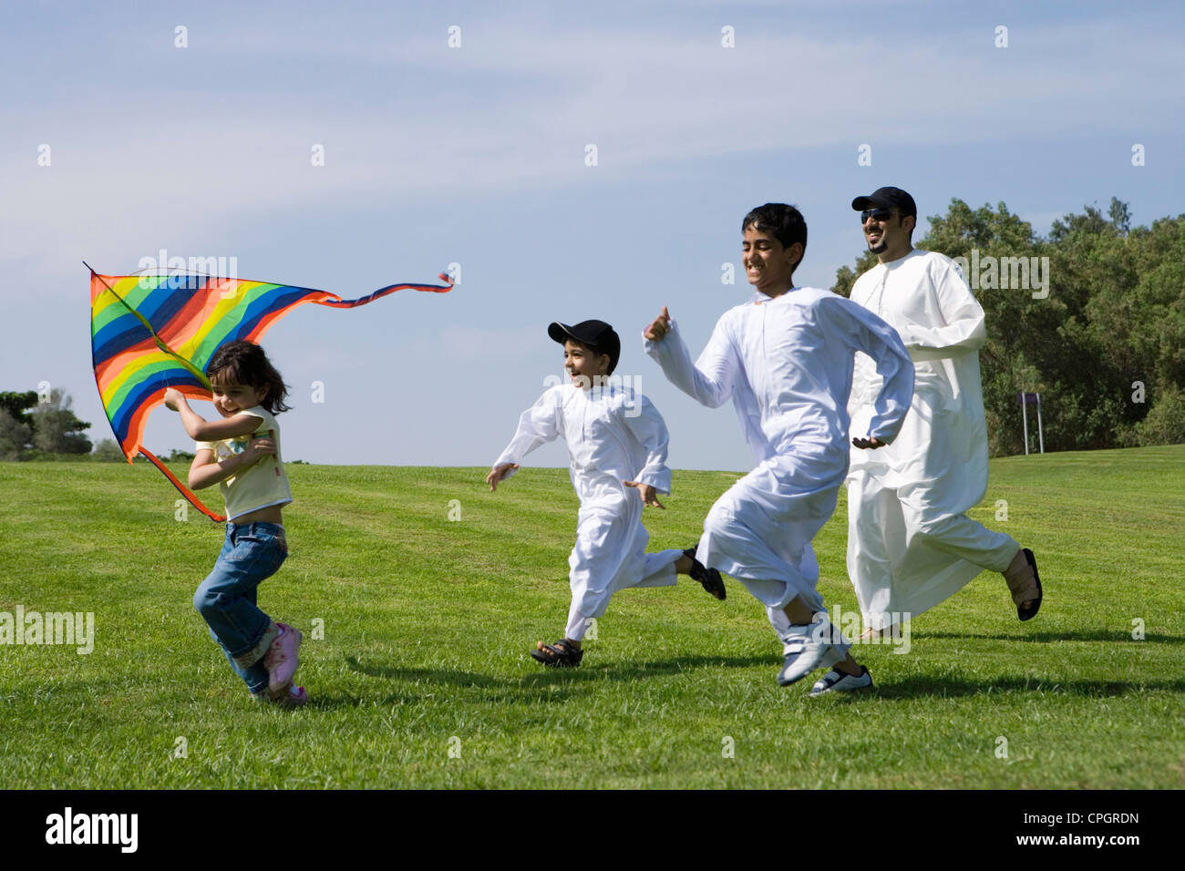 Father with children running at park Stock Photo - Alamy