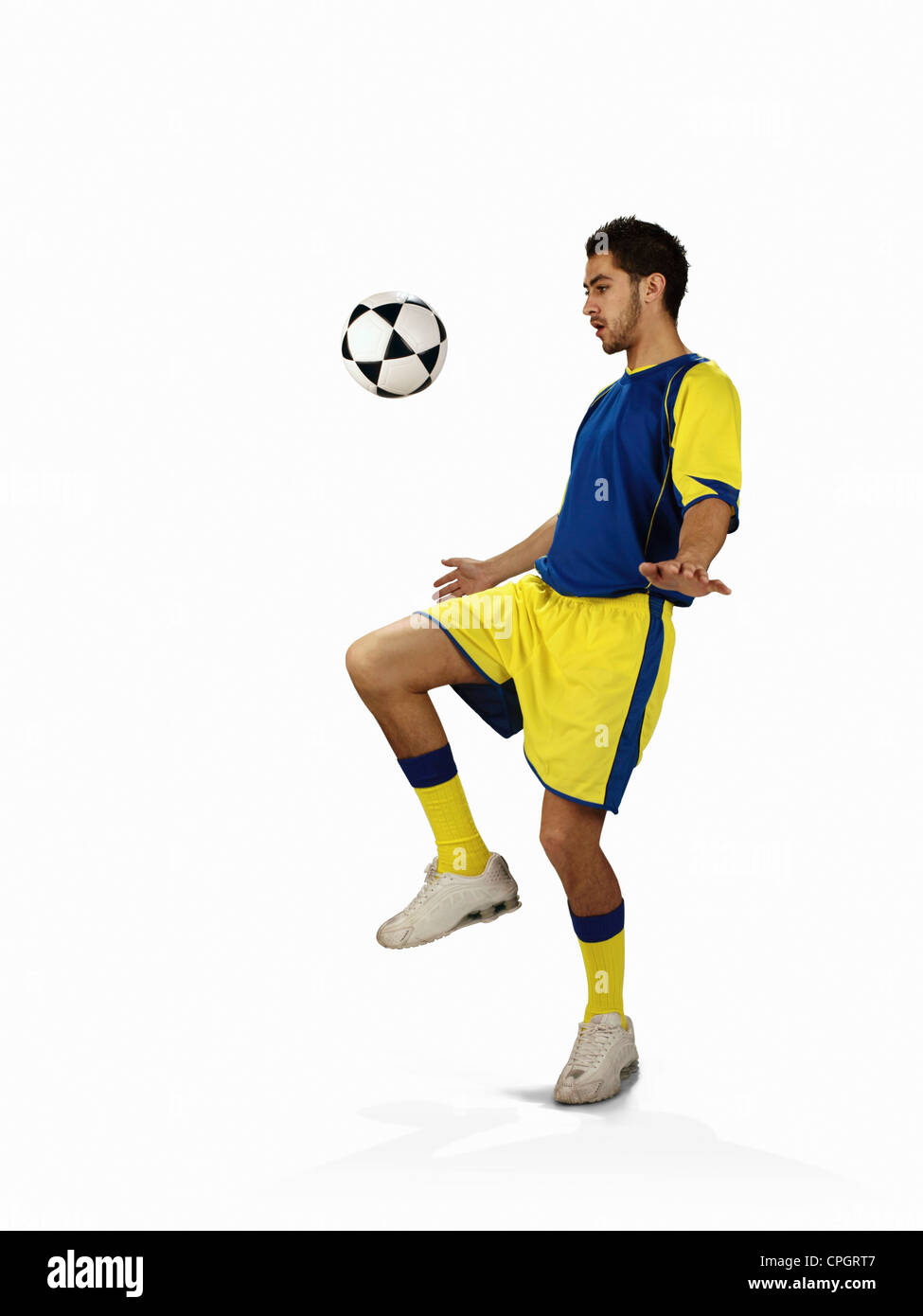 Young man playing with soccer ball, side view Stock Photo - Alamy