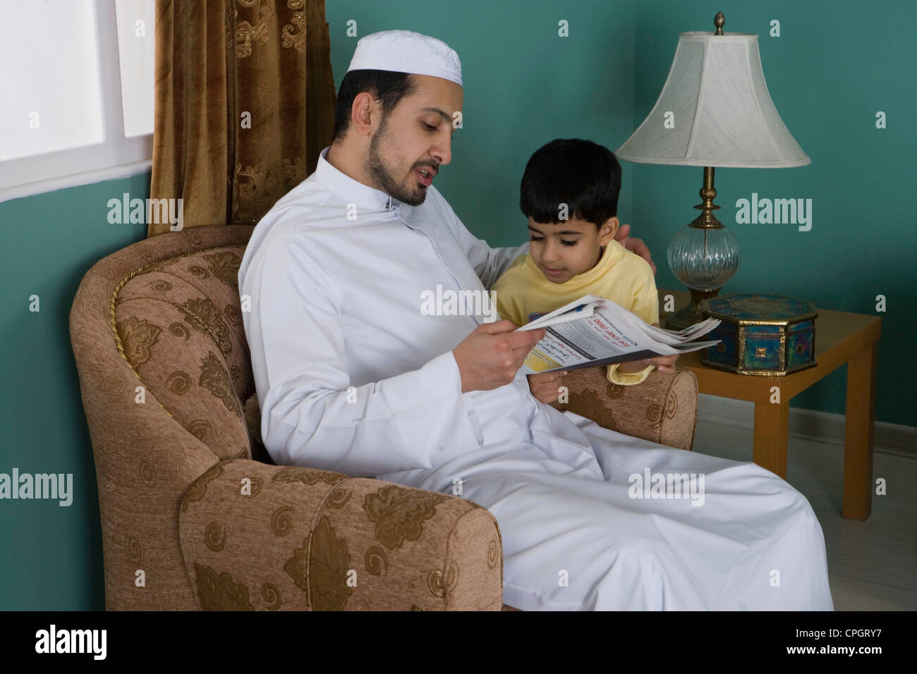 Father and son reading a newspaper together Stock Photo - Alamy