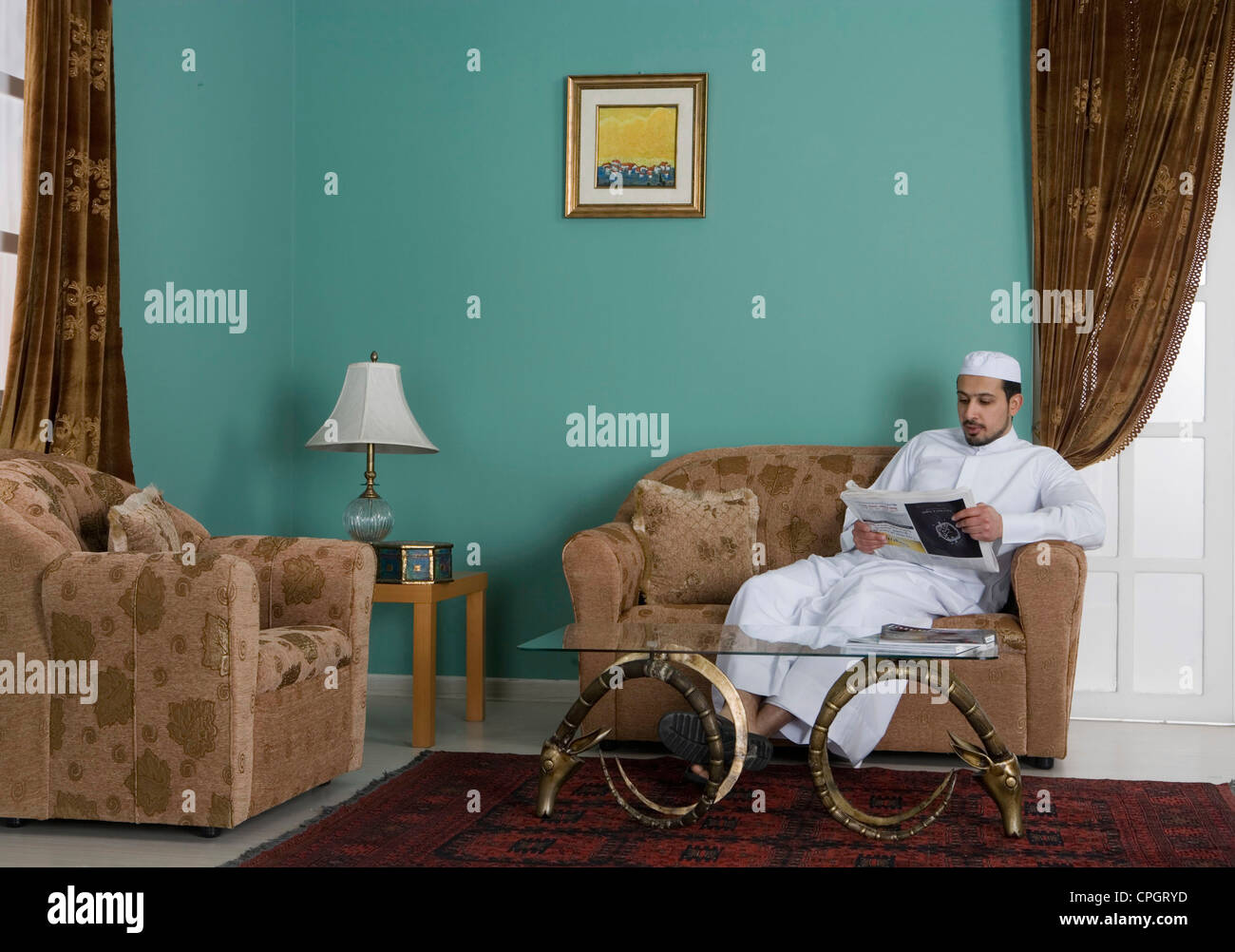 Arab man reading a newspaper in the living room Stock Photo - Alamy