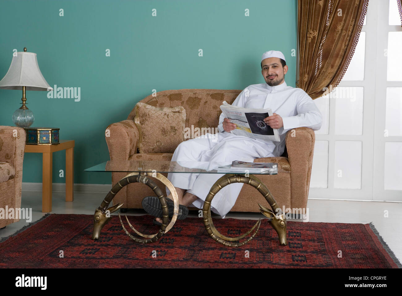Arab man reading a newspaper in the living room Stock Photo - Alamy