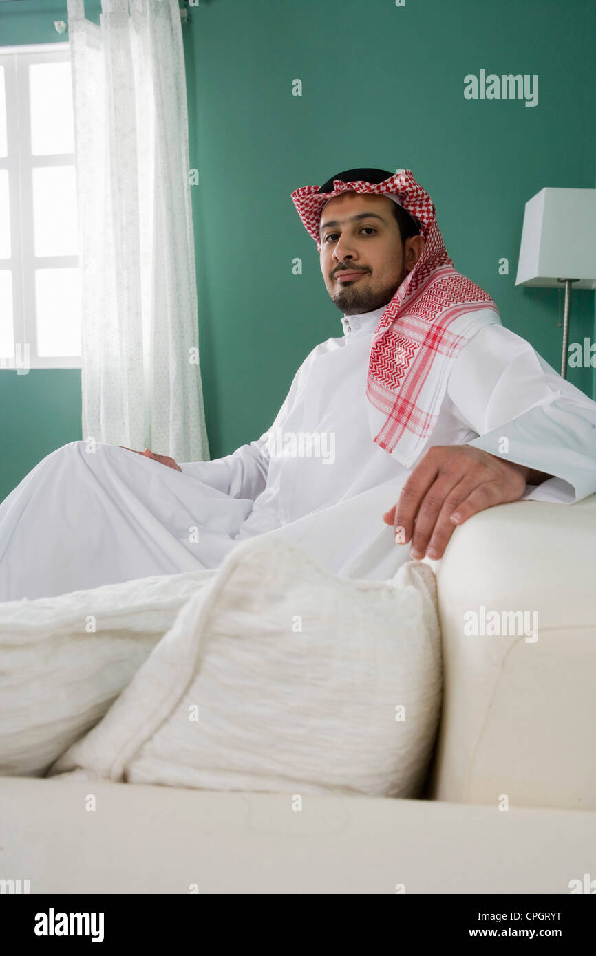 Arab man sitting on sofa Stock Photo - Alamy