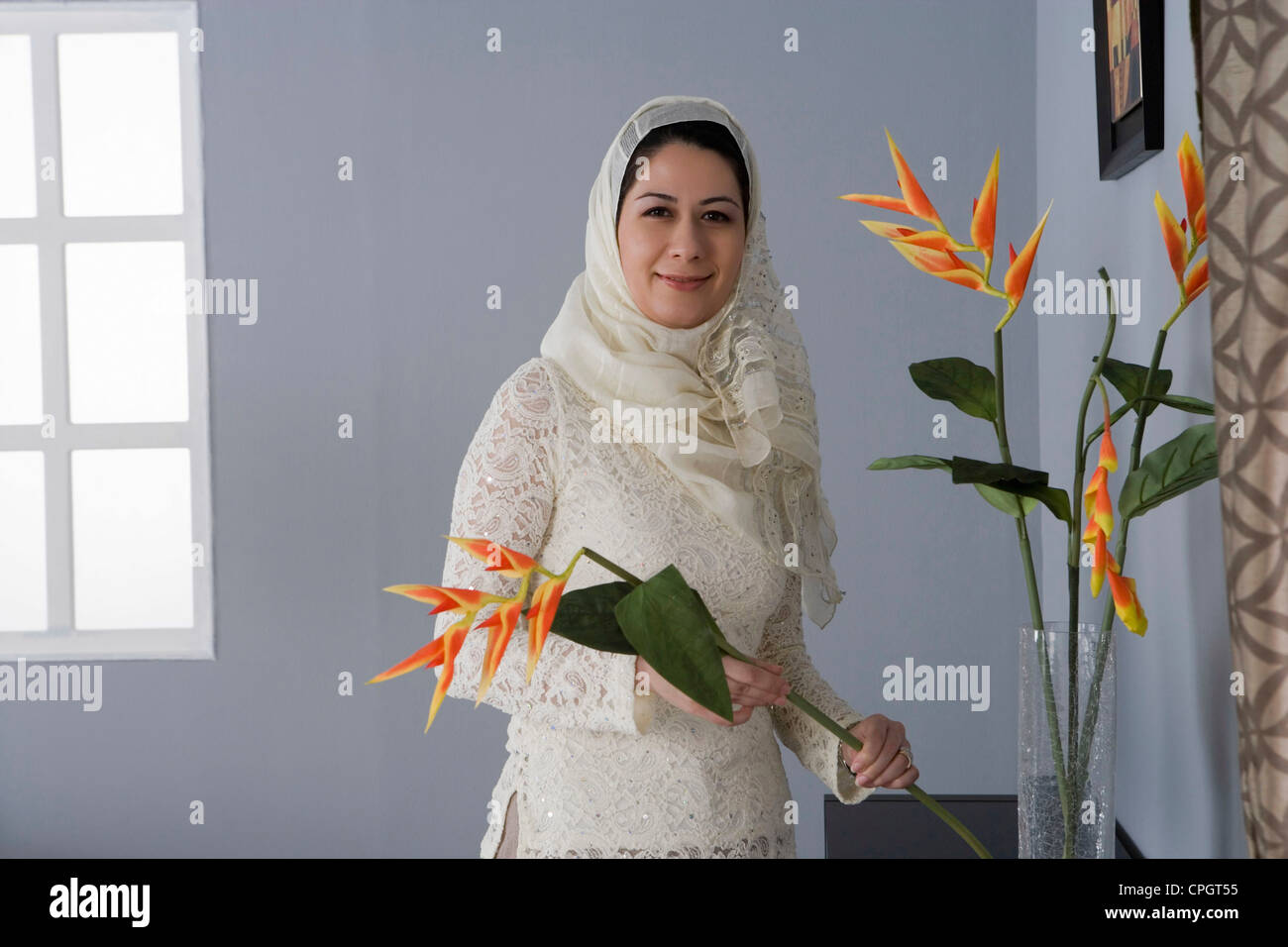 Arab woman arranging flowers in a vase Stock Photo - Alamy