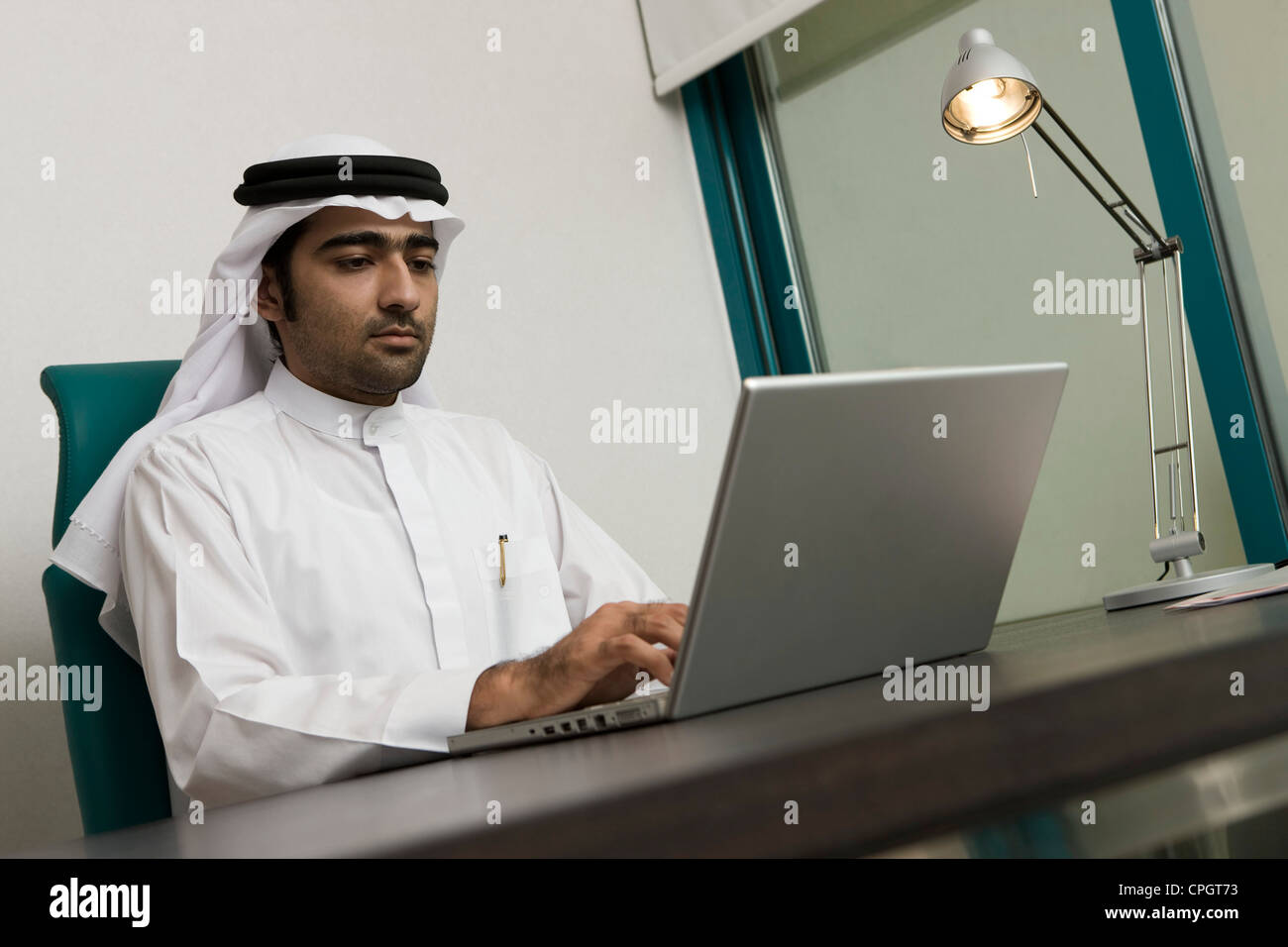 Arab businessman typing on a laptop, sitting at the office Stock Photo ...