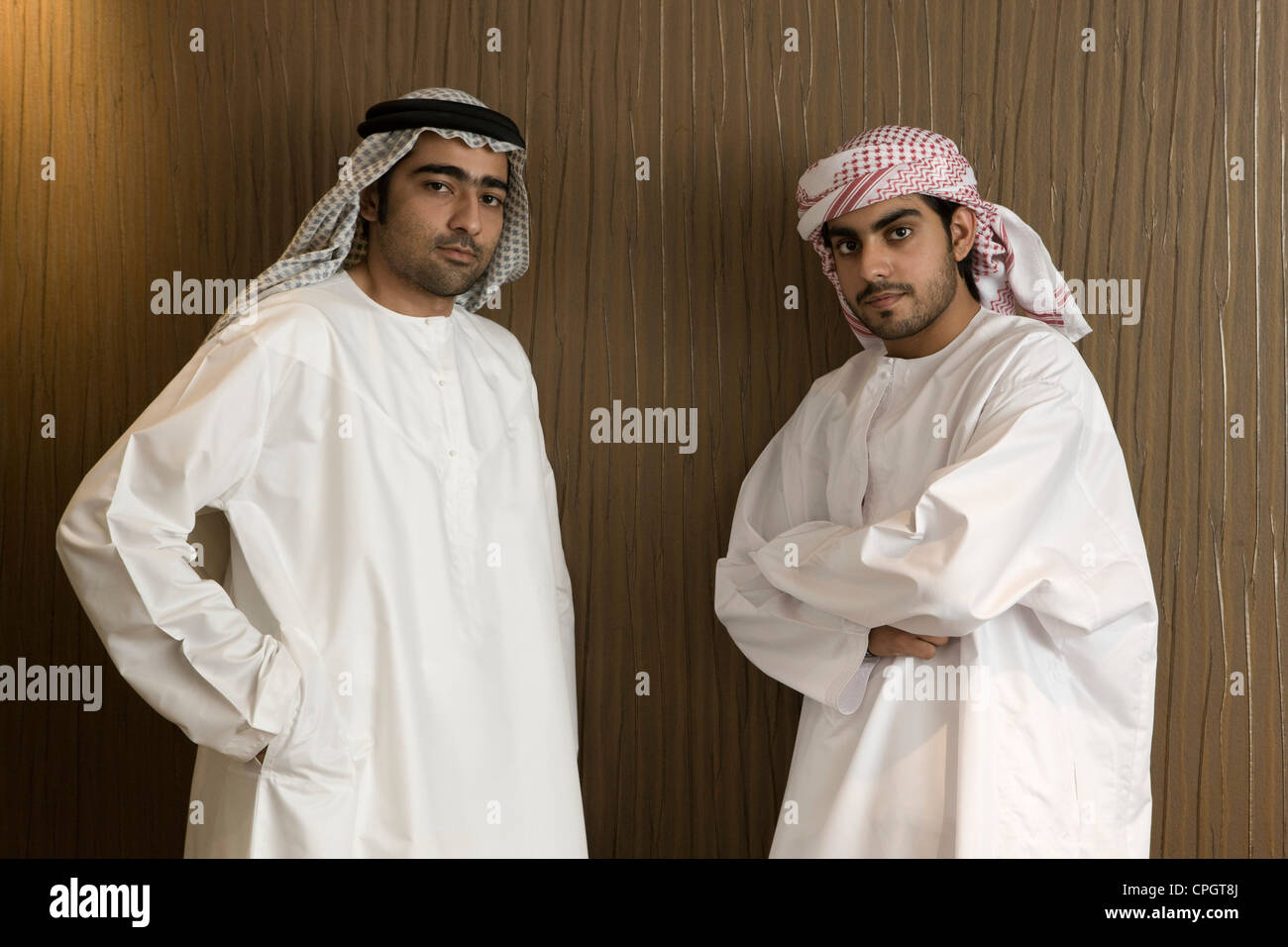 Two Arab men standing near the office wall, portrait Stock Photo - Alamy
