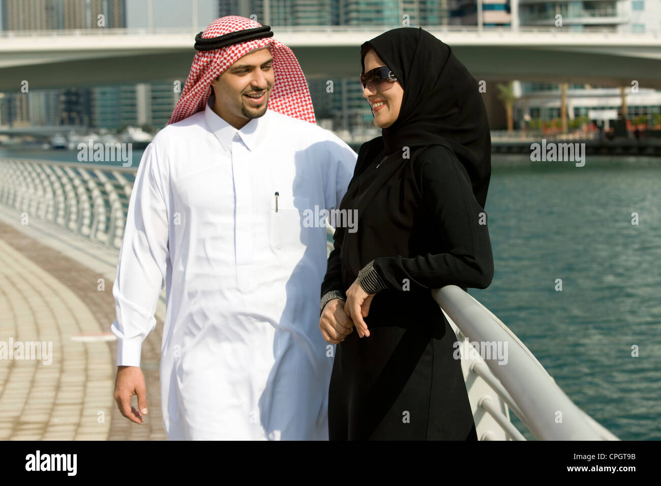 Arab couple standing by the railing in Dubai Marina, UAE Stock Photo ...