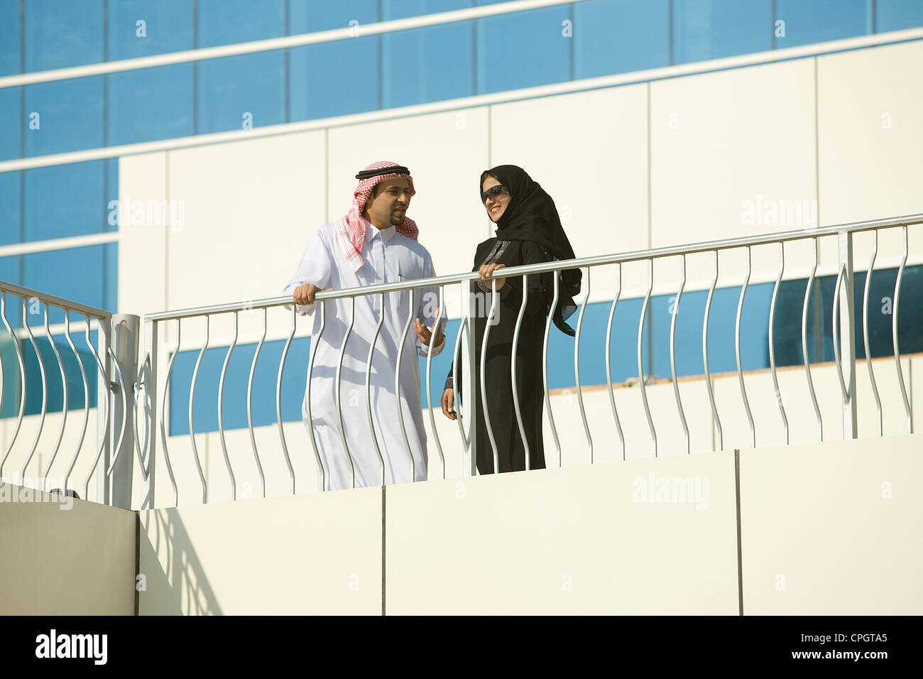 Arab couple standing by the railing of a building at Dubai, UAE Stock ...