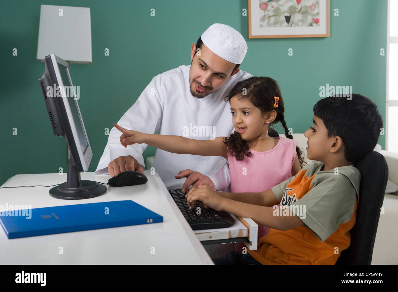 Arab father and children in front of a computer Stock Photo - Alamy