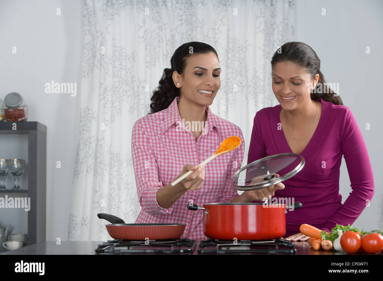 Two women cooking in the kitchen Stock Photo - Alamy