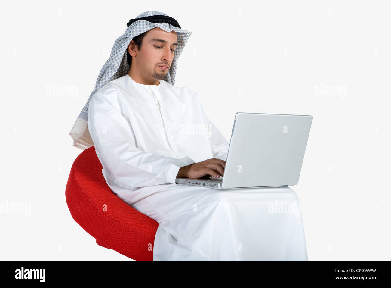 Young man sitting on chair, using laptop Stock Photo - Alamy