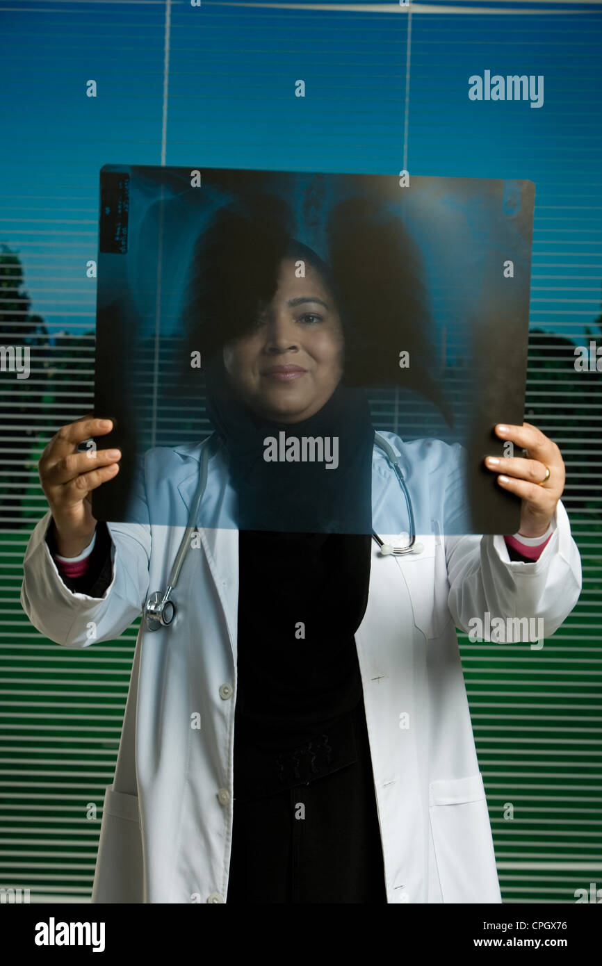 Female doctor holding X-ray, smiling, portrait Stock Photo - Alamy