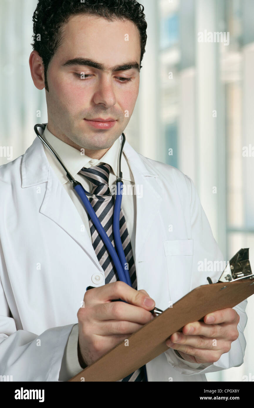 Doctor writing in medical record Stock Photo - Alamy