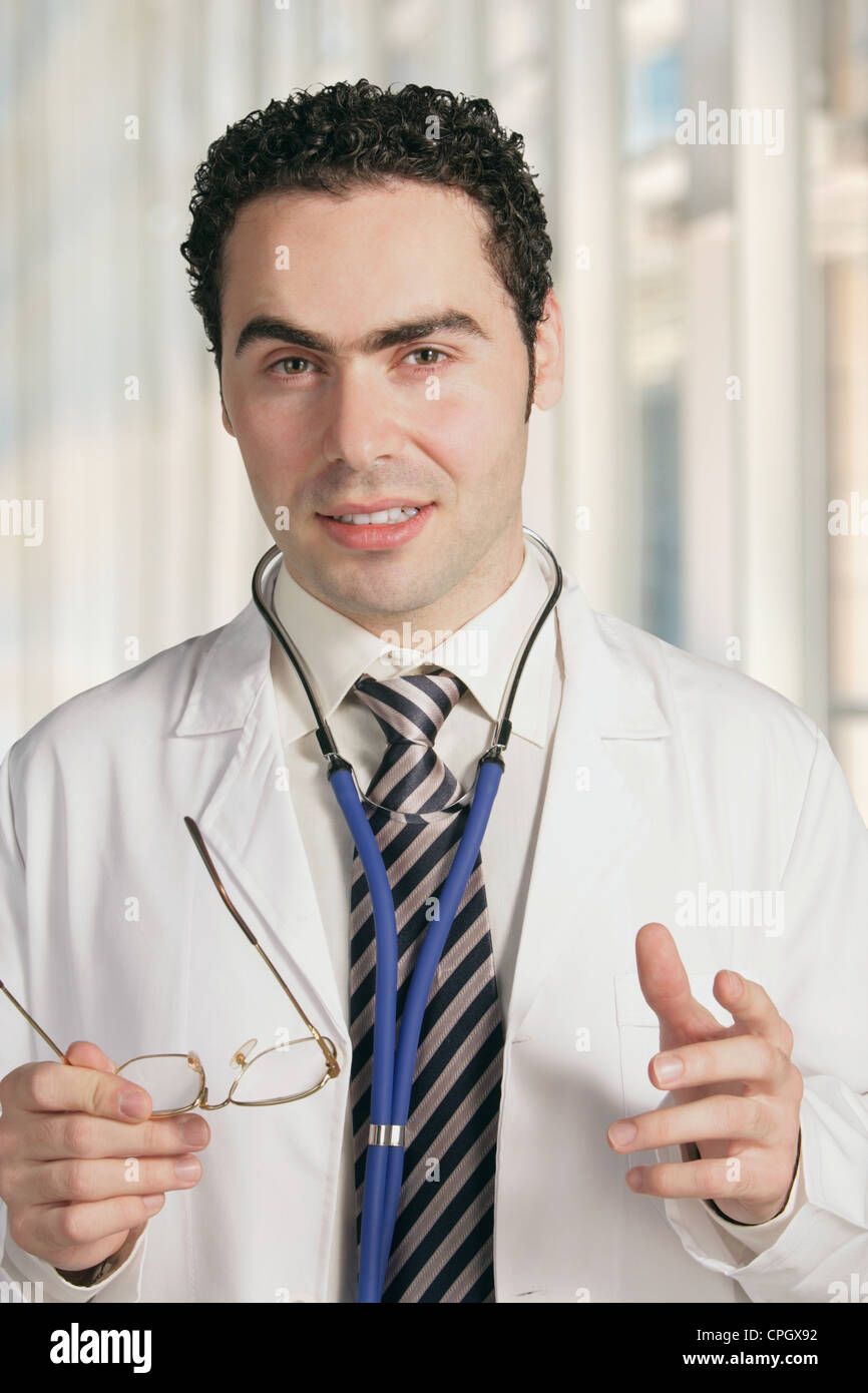Portrait of doctor holding glasses Stock Photo - Alamy