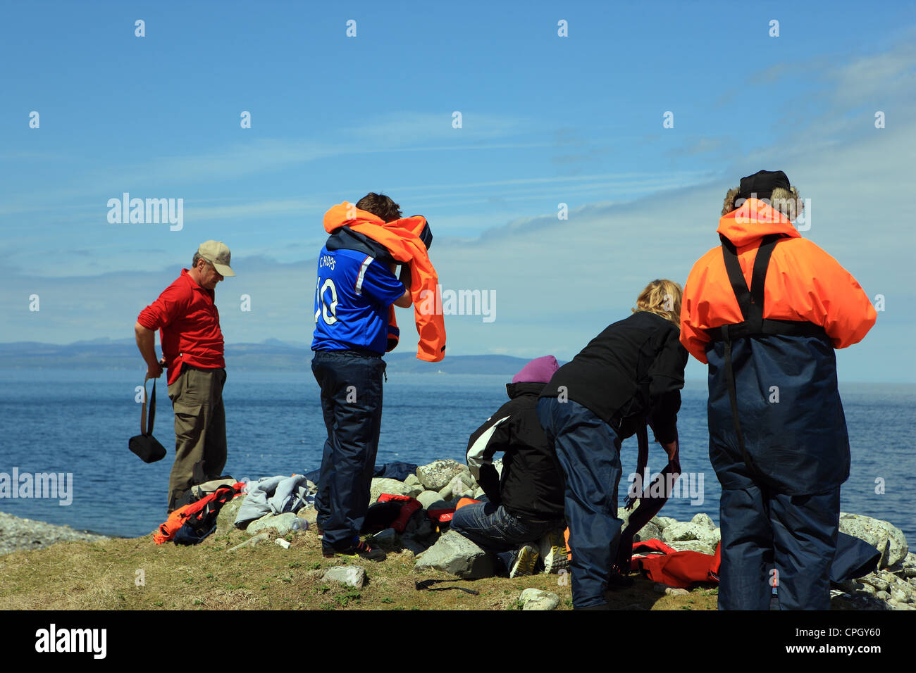 People getting changed into waterproof sailing clothing Stock Photo - Alamy