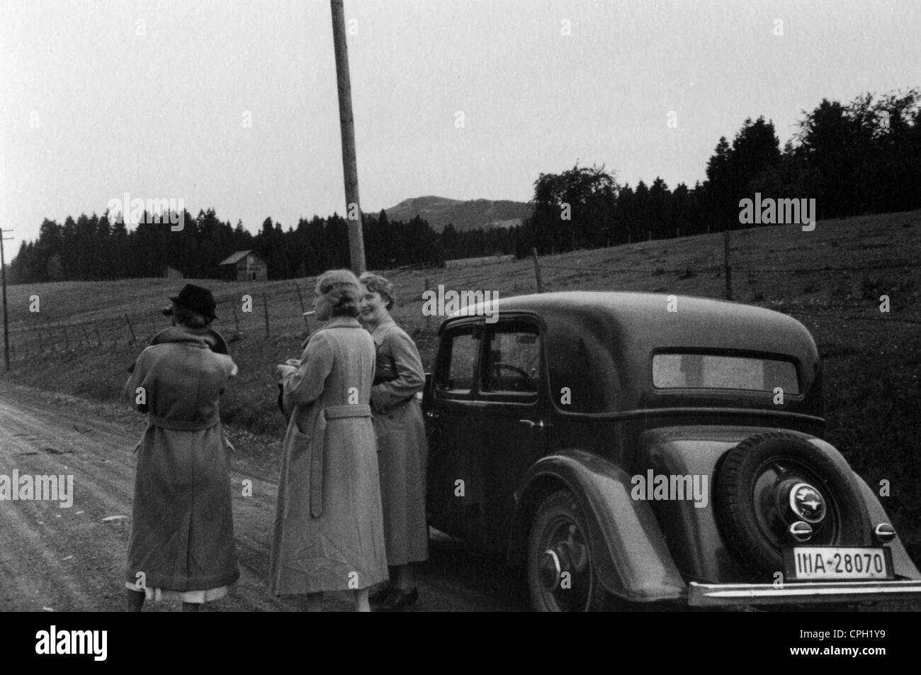 people, women, three women during cigarette break beside their car on a ...