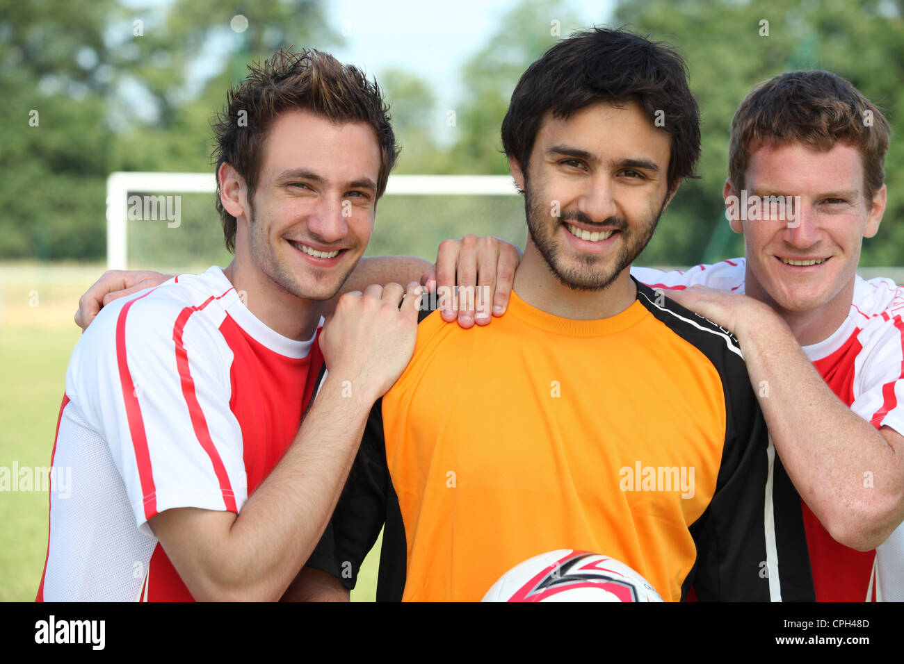 Three young football players on a football field Stock Photo - Alamy
