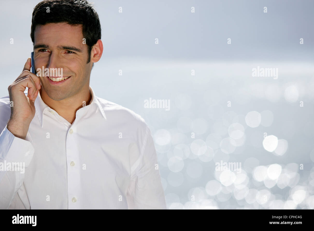 Smiling man having phone conversation Stock Photo - Alamy