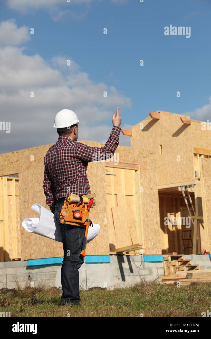 Foreman overseeing the wooden house build Stock Photo - Alamy