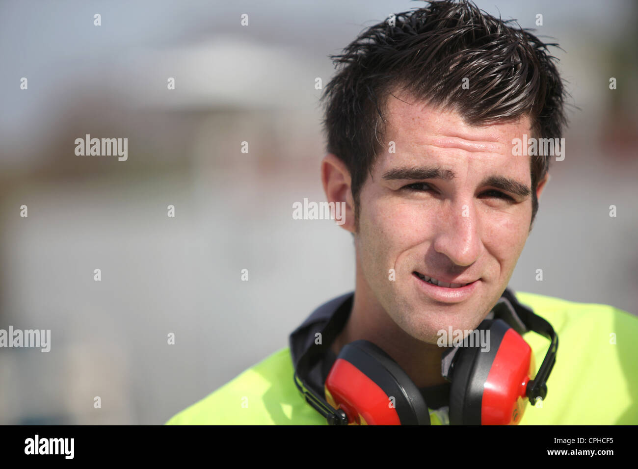 Construction worker with ear defenders Stock Photo - Alamy