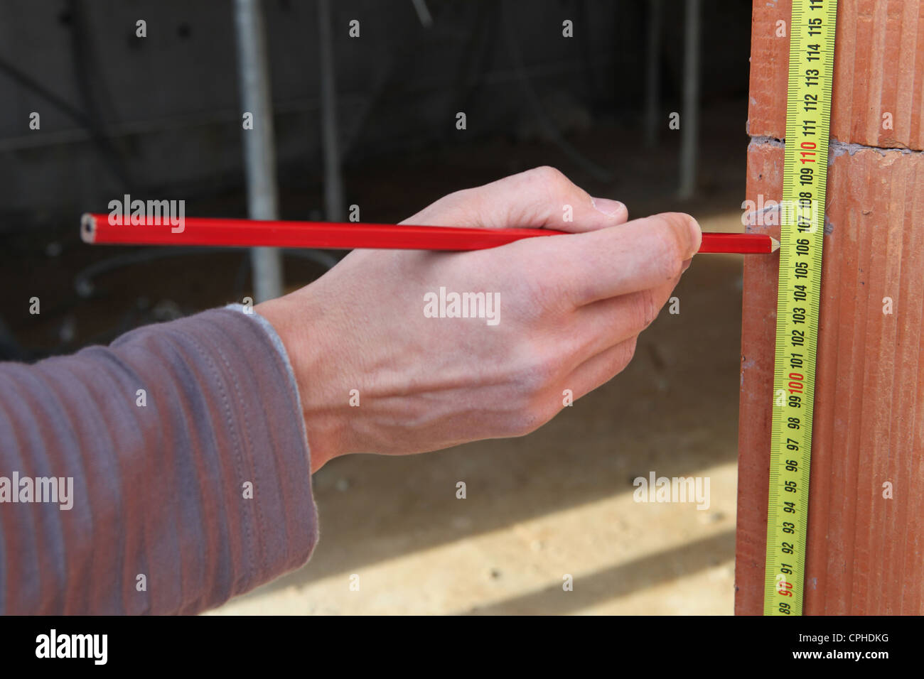 Man measuring brick wall Stock Photo - Alamy