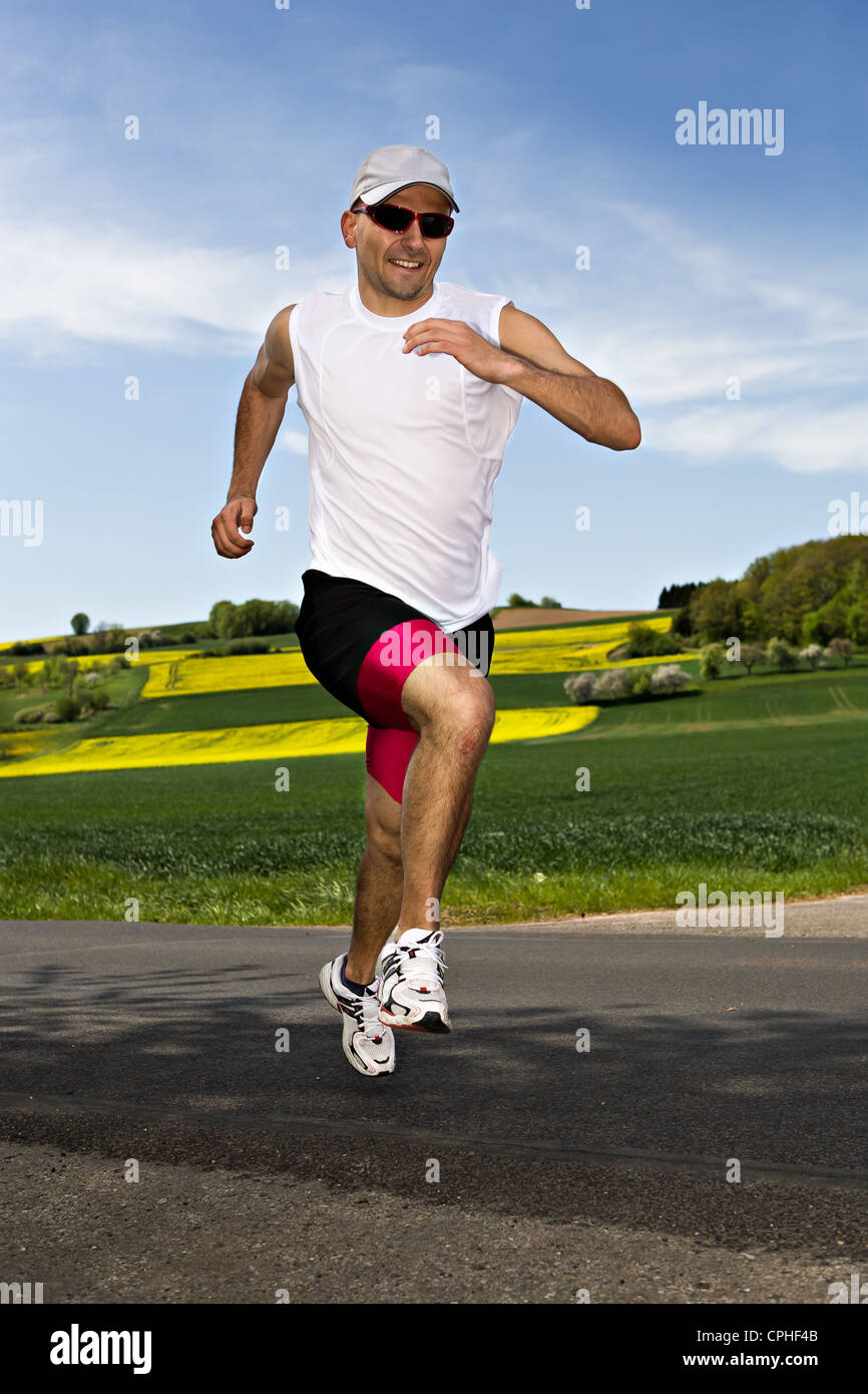 a young man jogging through the fields Stock Photo - Alamy