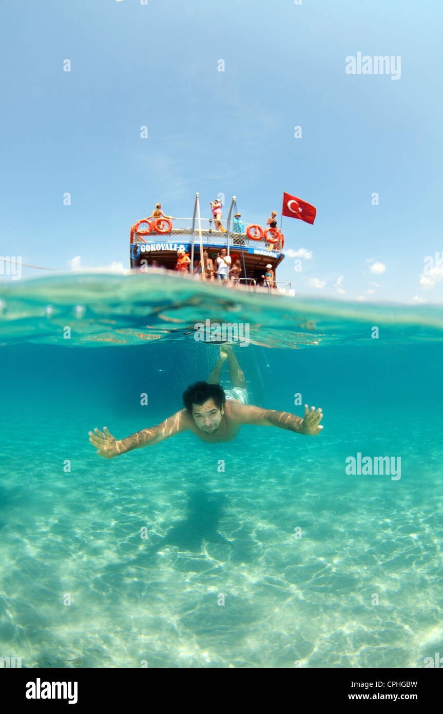 Split level, man diving next to the tour boat, Cleopatra island (Sedir ...