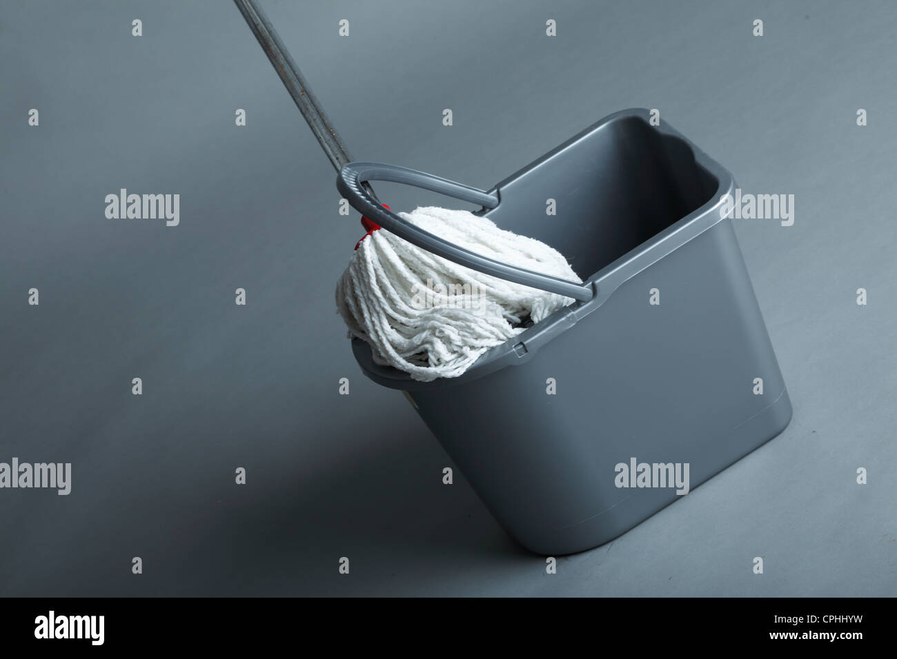 Industrial mop and bucket on grey background Stock Photo - Alamy