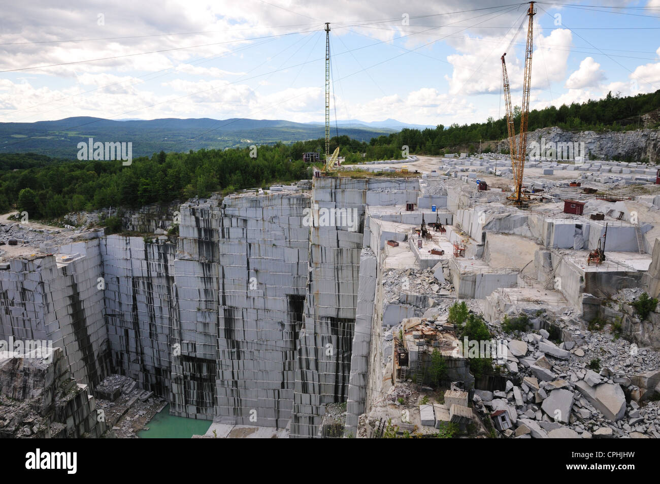 Tall cranes assist in excavation of granite at the Rock of Ages quarry ...