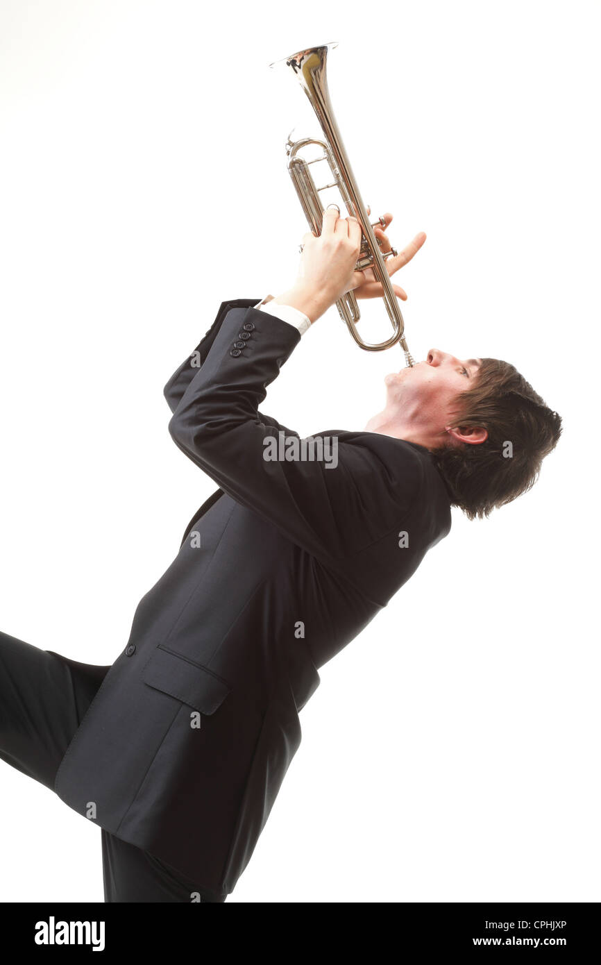 Portrait of a young man playing his Trumpet plays isolated white ...