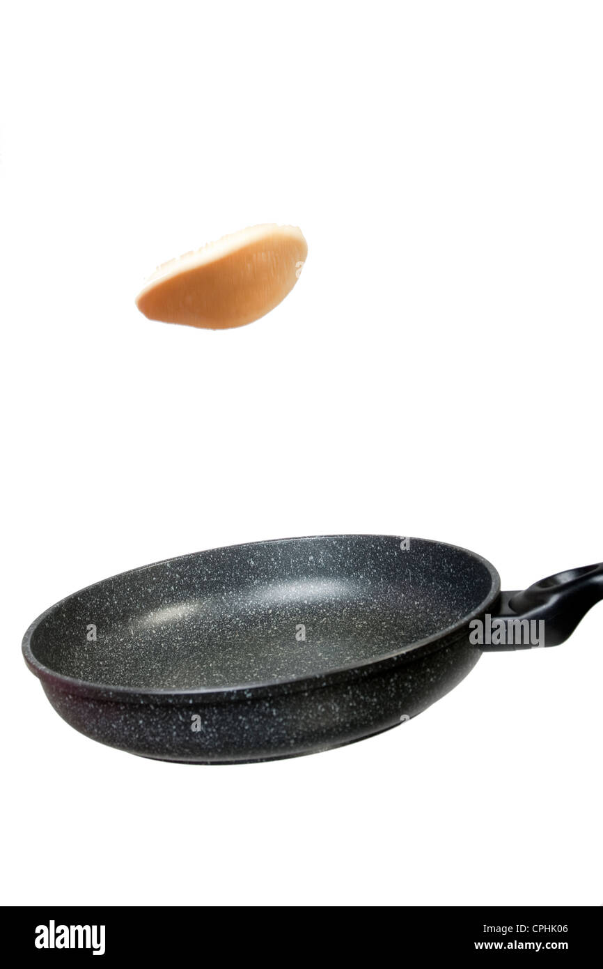 The process of flipping a pancake in a frying pan against a white ...