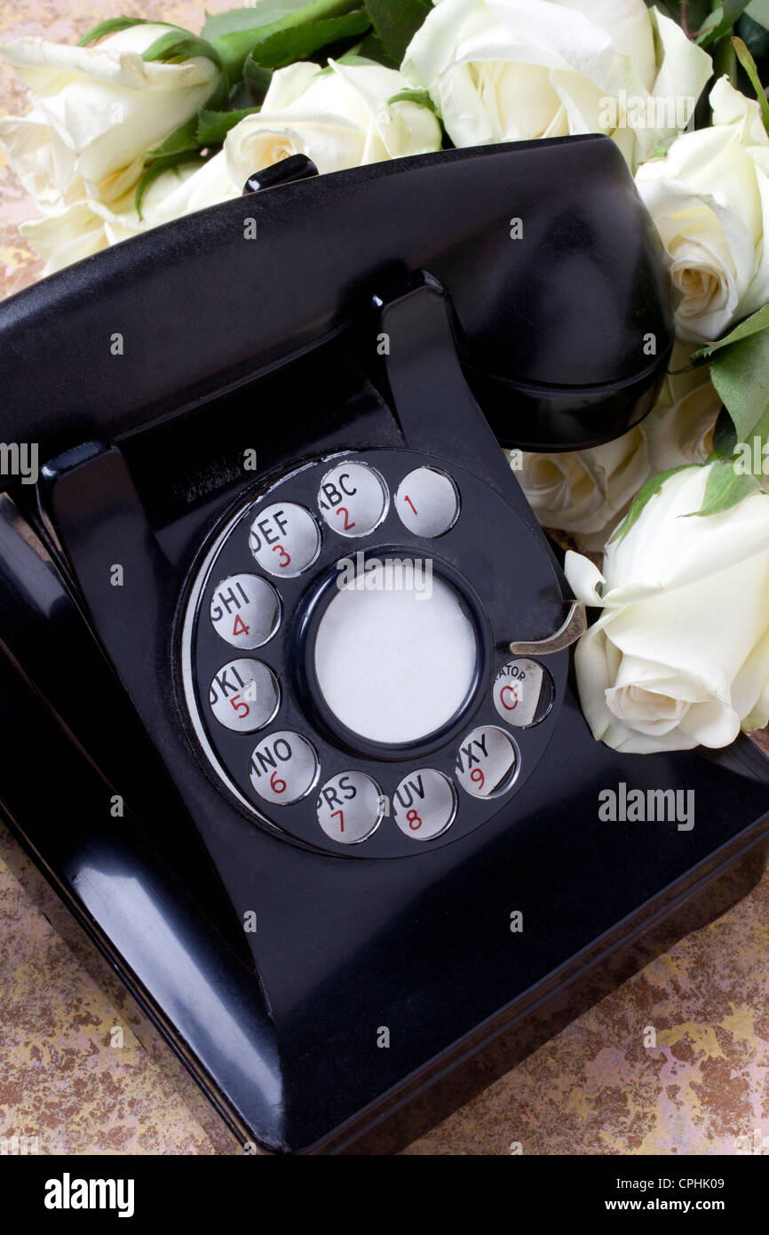 Old phone and white roses Stock Photo - Alamy