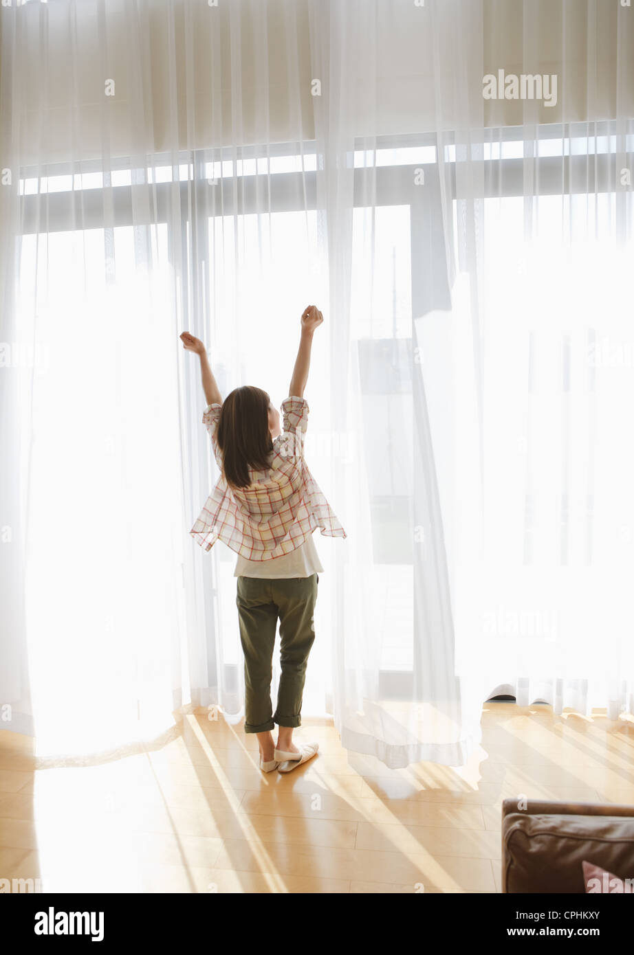 Back view of a woman stretching by a window Stock Photo - Alamy