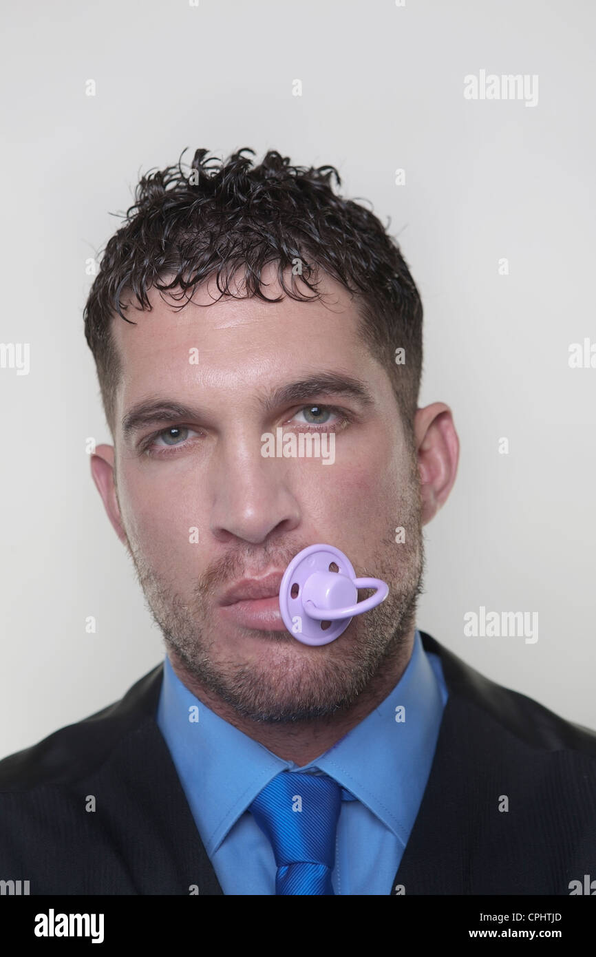 handsome man with a baby dummy in his mouth looking silly Stock Photo ...