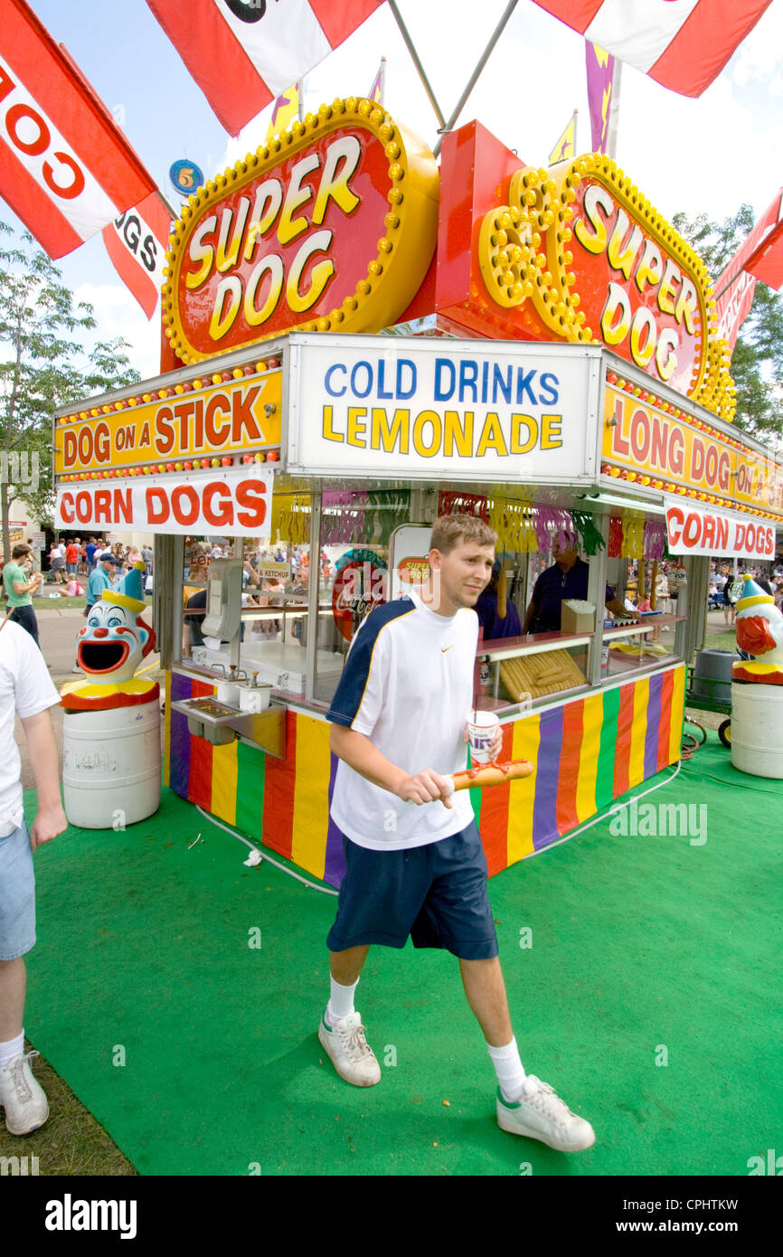 Teenager at a super dog fast food stand with a dog on a stick and ...