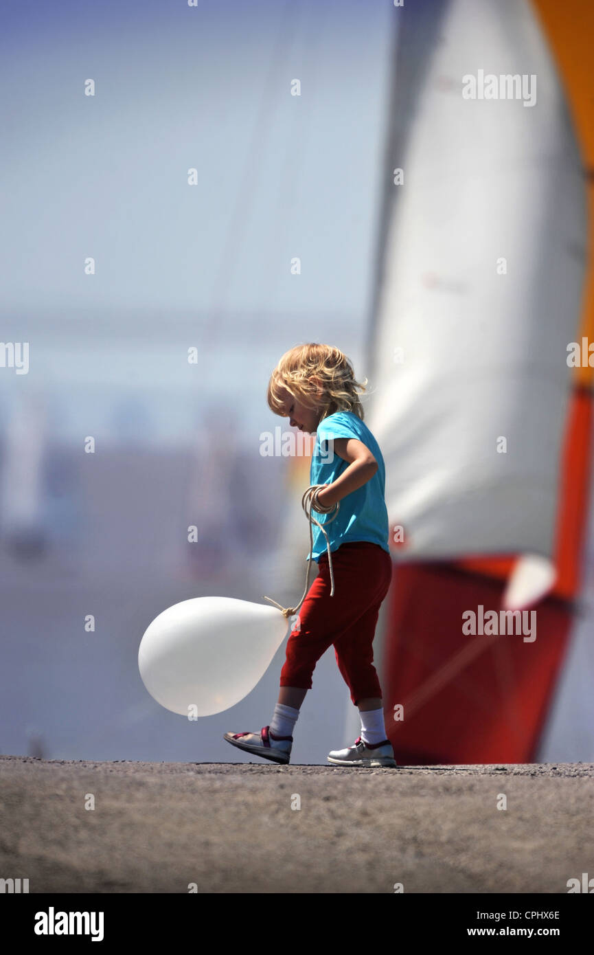 A child plays with a mooring buoy as a balloon at a regatta on the ...