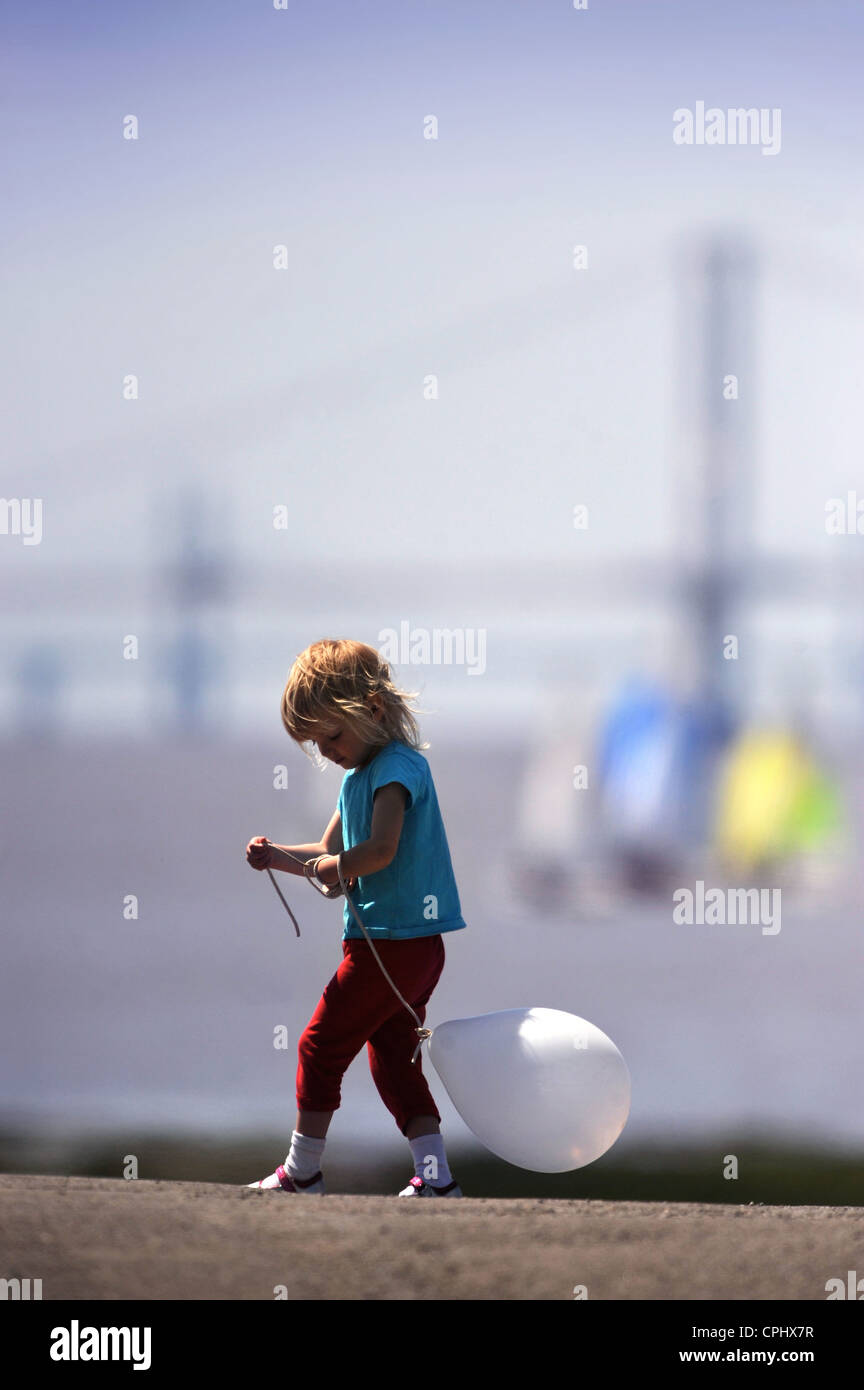 A child plays with a mooring buoy as a balloon at a regatta on the ...